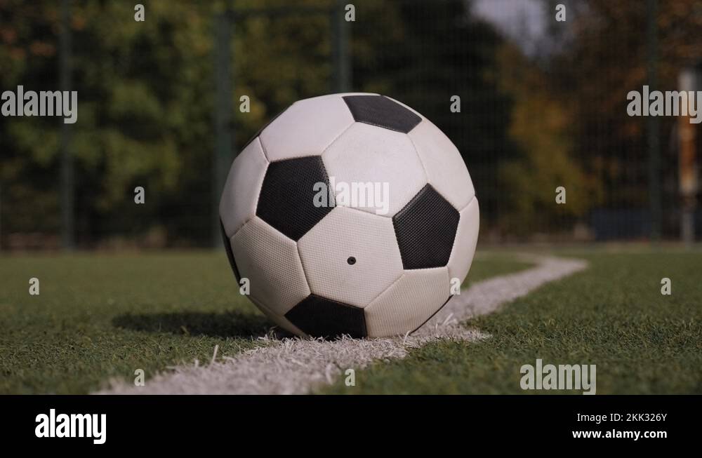 Close-up of schoolboy boy in football boots hitting the goal with a ...