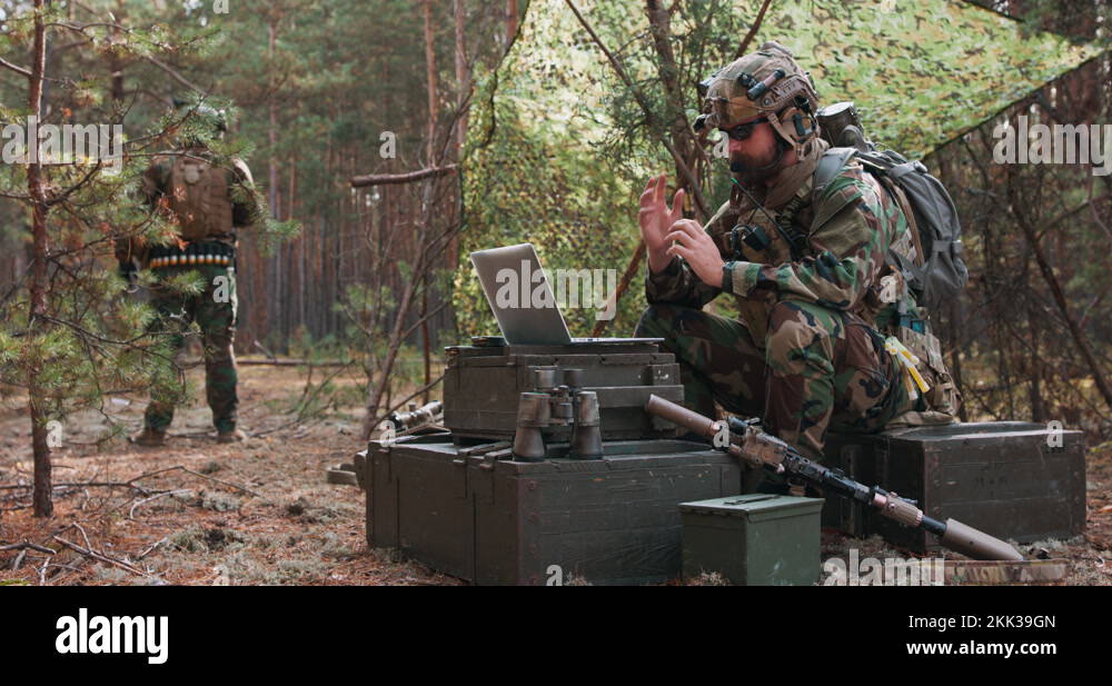 A bearded commander in a military uniform, in a tactical vest with a ...