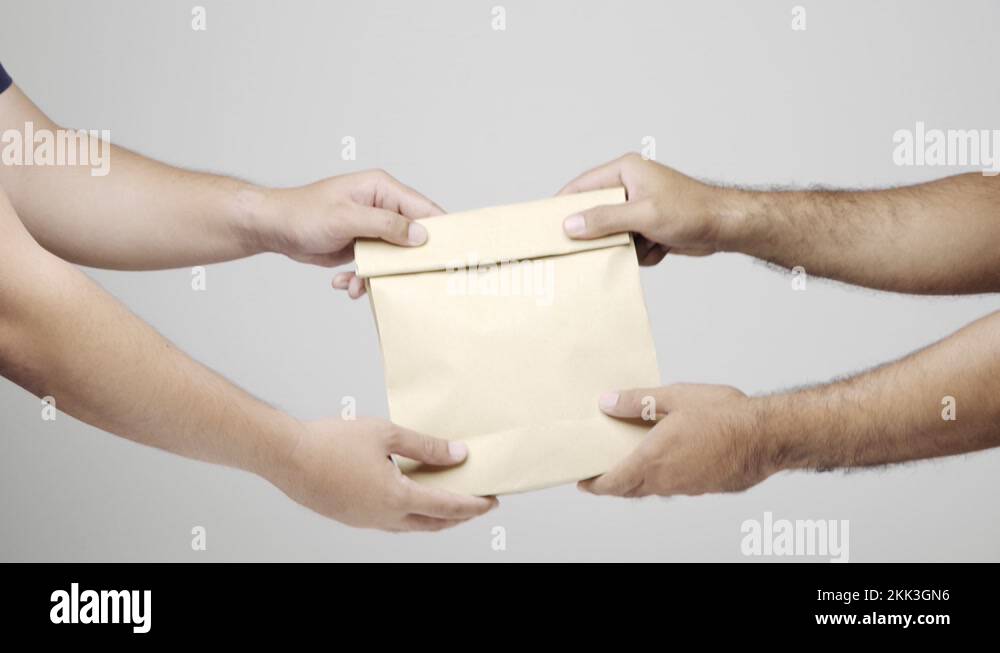 Close up male hands receive the food paper bag from delivery man on ...