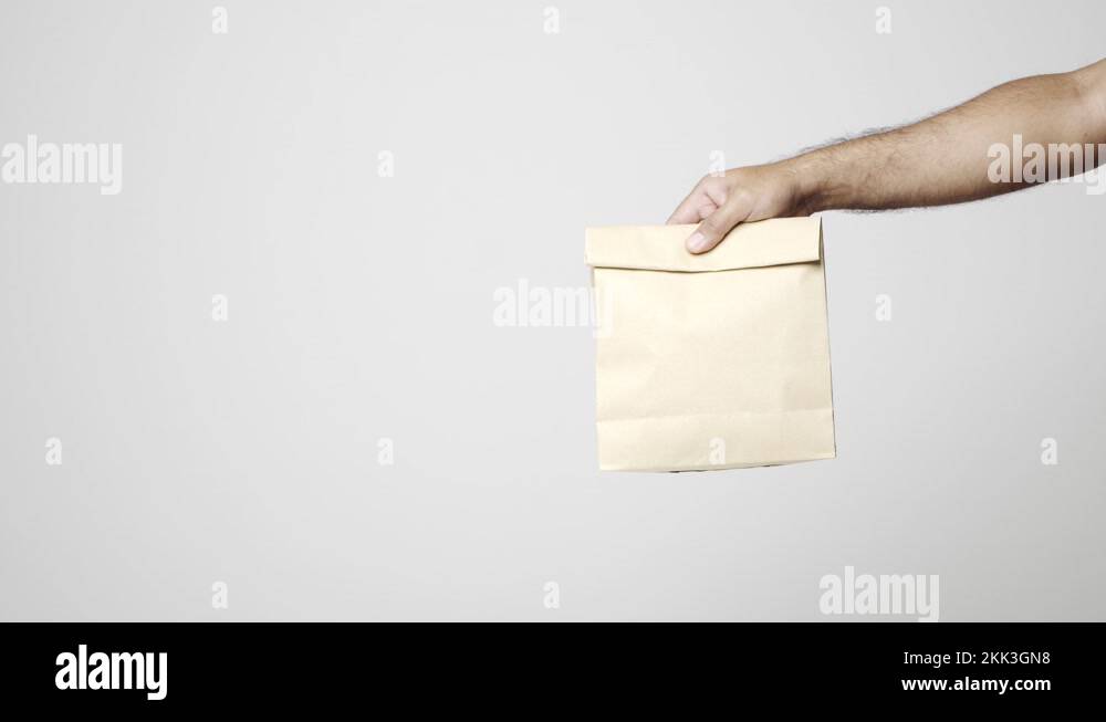 Close up hands delivery man sending the food paper bag on isolated ...