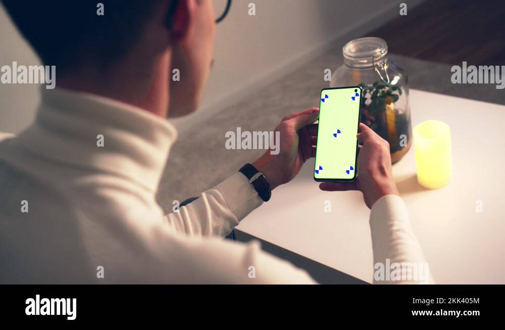 Relaxed young man using smart phone with green screen chroma key. Guy ...