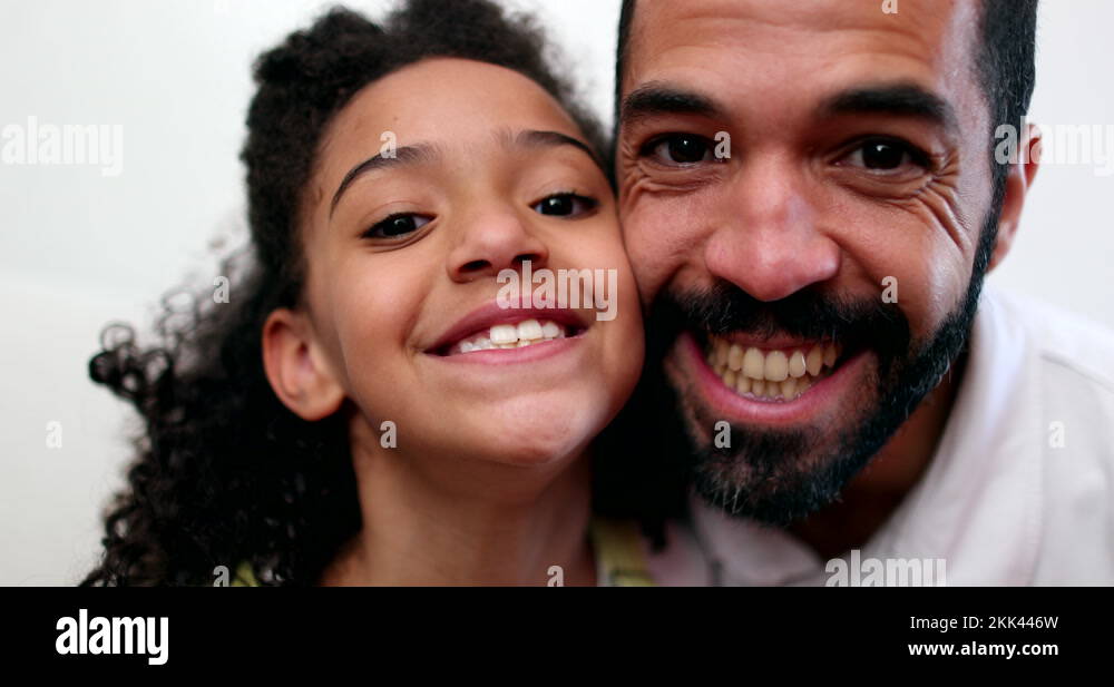 Mixed race father and daughter smiling to camera. Little girl and dad ...