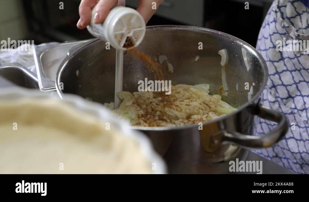 Cook Adding Seasoning On Casserole Of Cooked Onions In The Kitchen ...