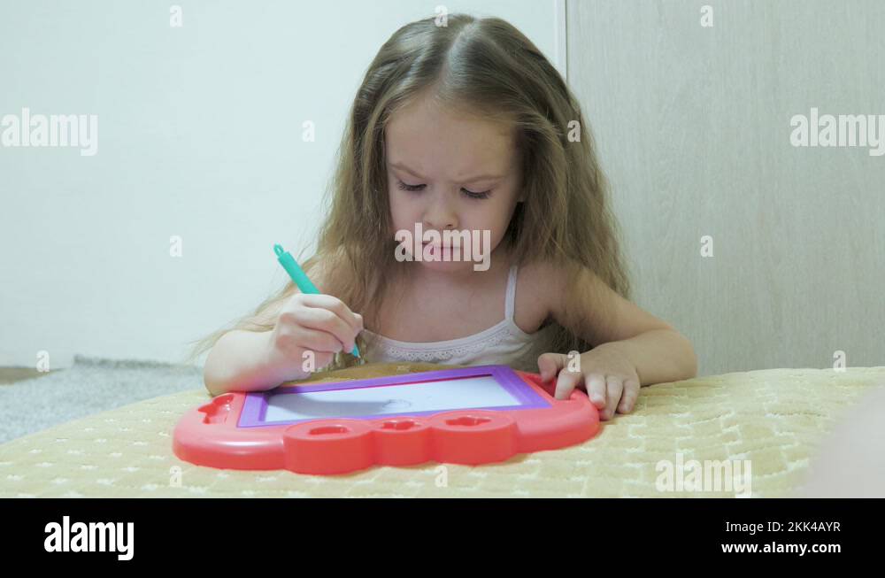 Cute little kid girl artist playing alone drawing coloring picture with ...