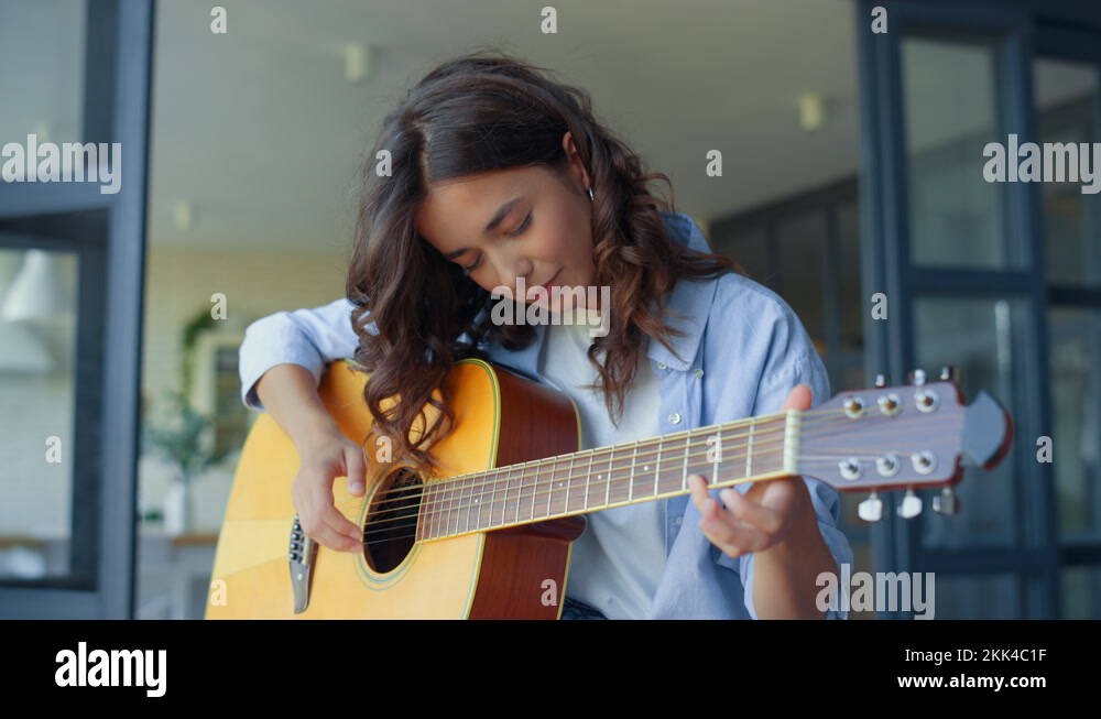 Girl practicing music on guitar. Female guitarist playing chords on ...