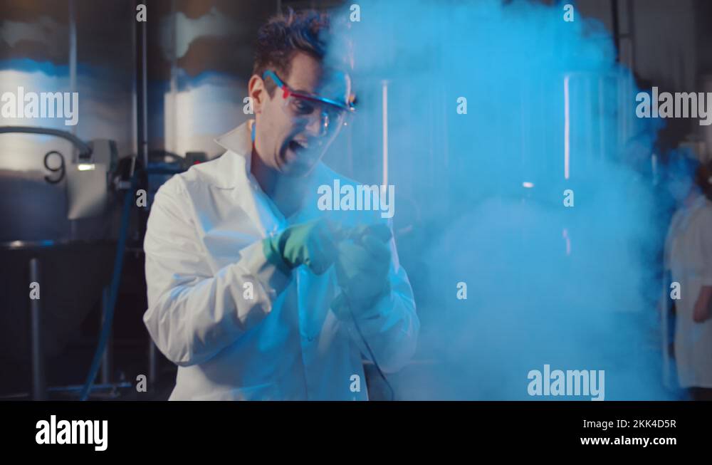 Evil professor pushing remote controller button in large industrial ...