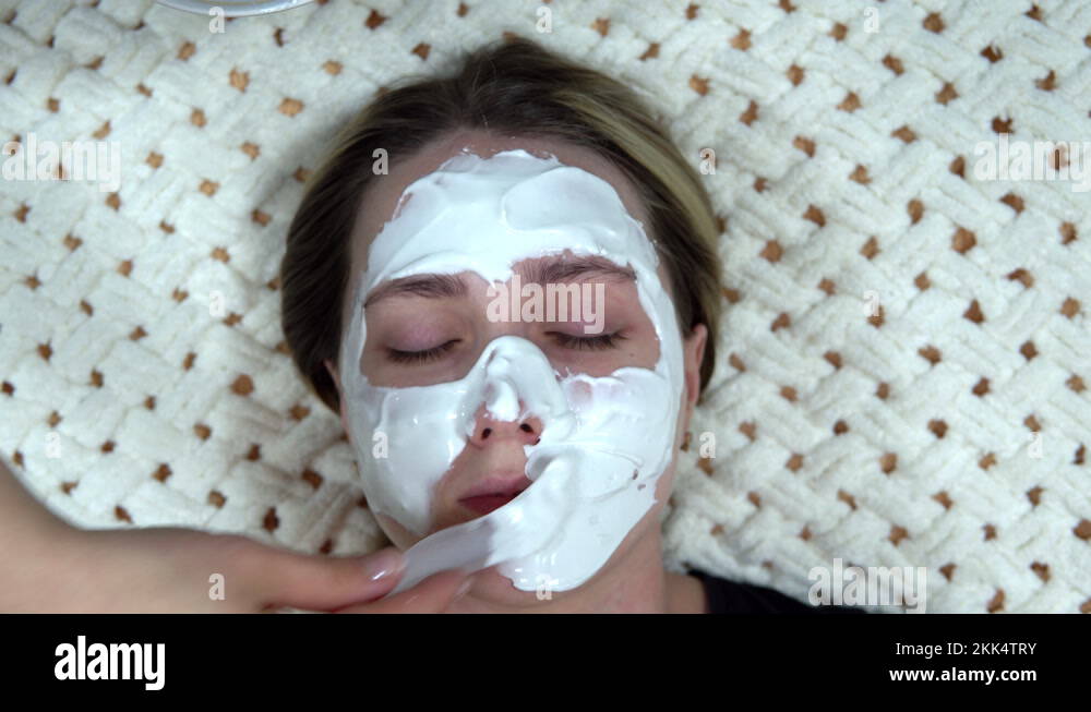 A white alginate mask is applied to a woman to rejuvenate her skin ...