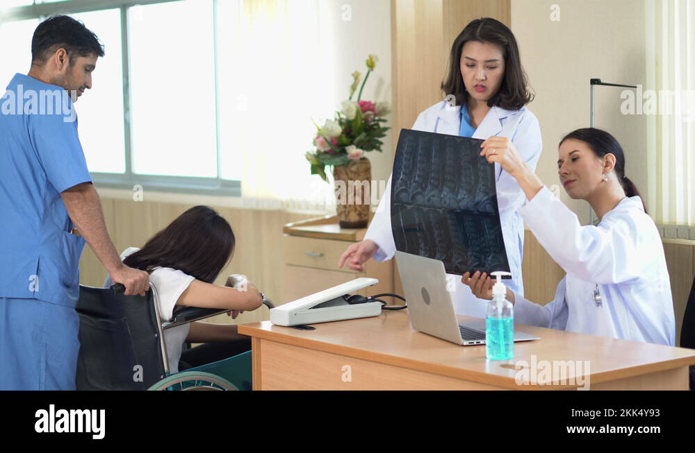 group of diverse medical team explaining X-ray results with patient on ...