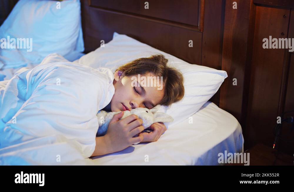 The teenage girl naps with a plush toy, sees a pleasant sleep and ...