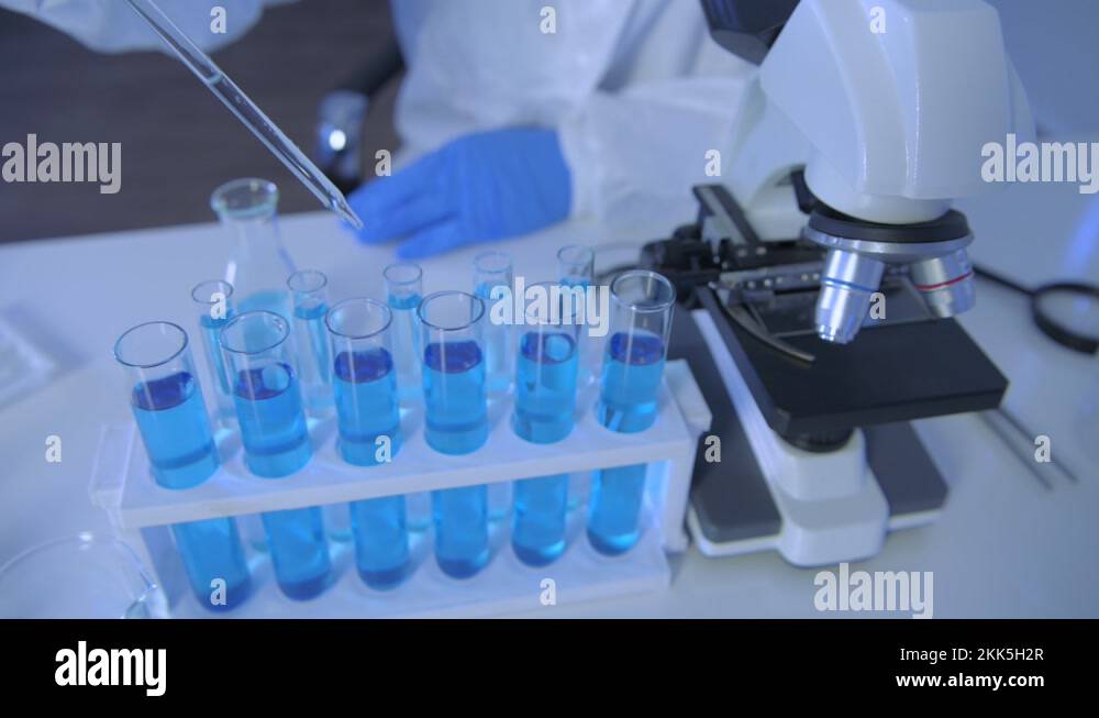 Research concept of 4k resolution. A scientist dripping liquid into a ...