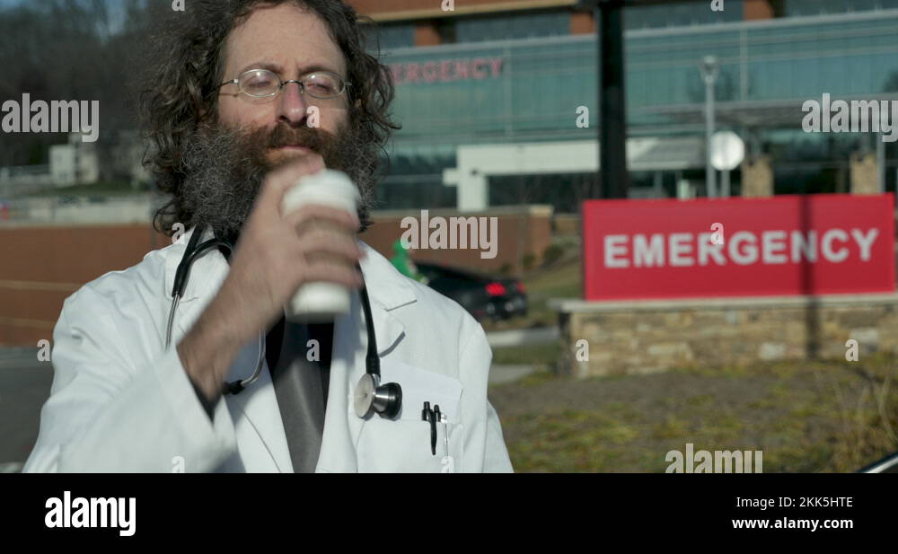 Worried male doctor standing outside of a emergency room hospital ...