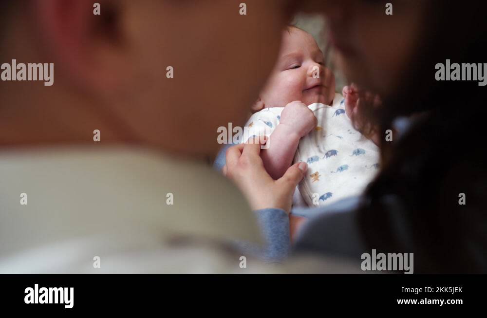 shooting over shoulder. a newborn baby is lying on the lap of his ...