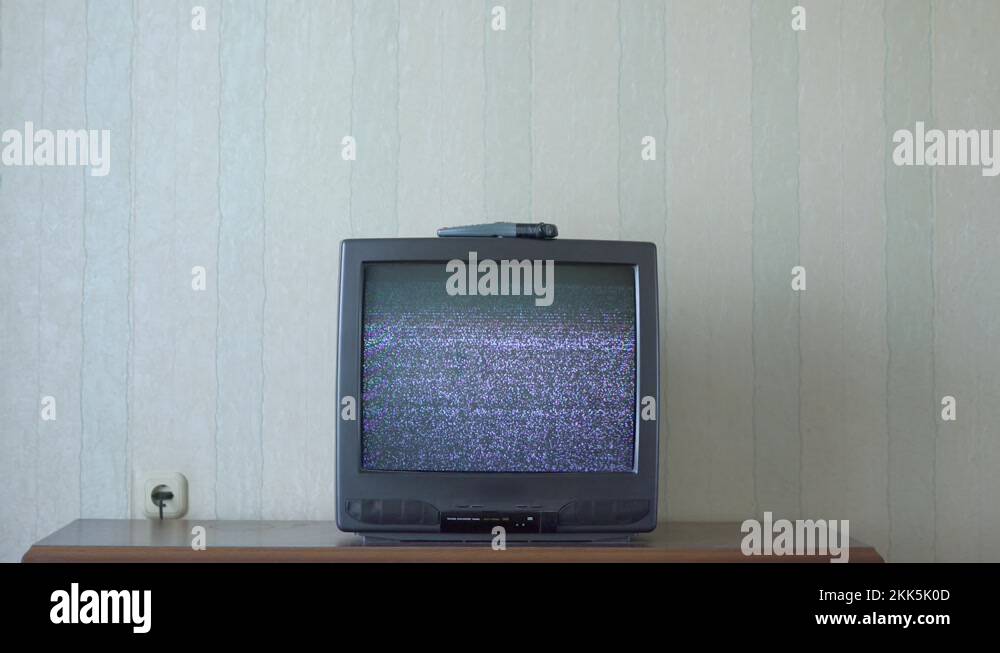 Old tv with static noise video image on screen stands on wooden desk of ...