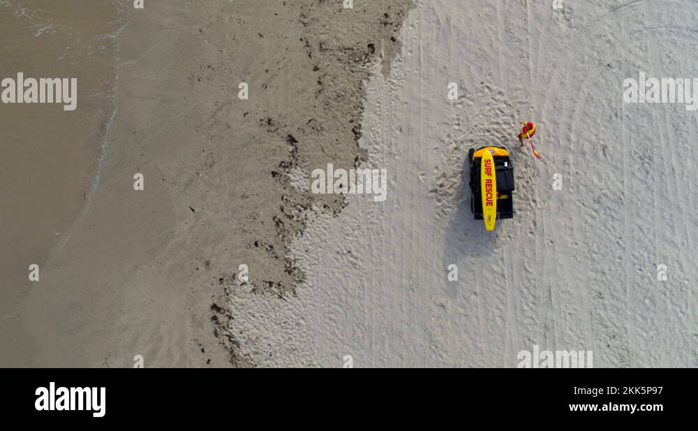Scarborough surf lifesaver putting out flags on a beach. Top down drone ...