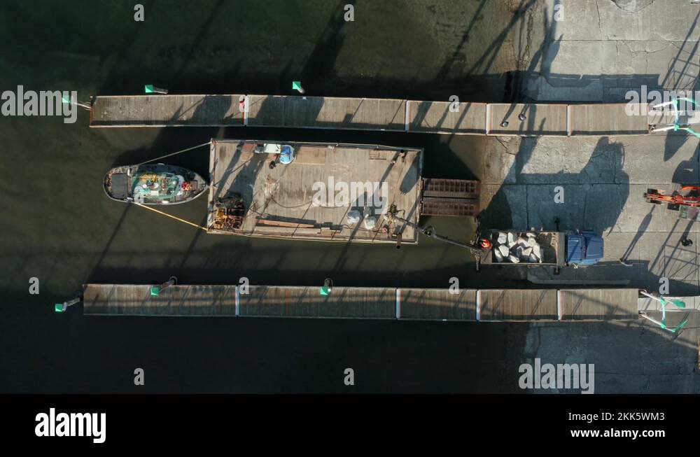 Loading a tugboat barge full of rocks for construction project on lake ...