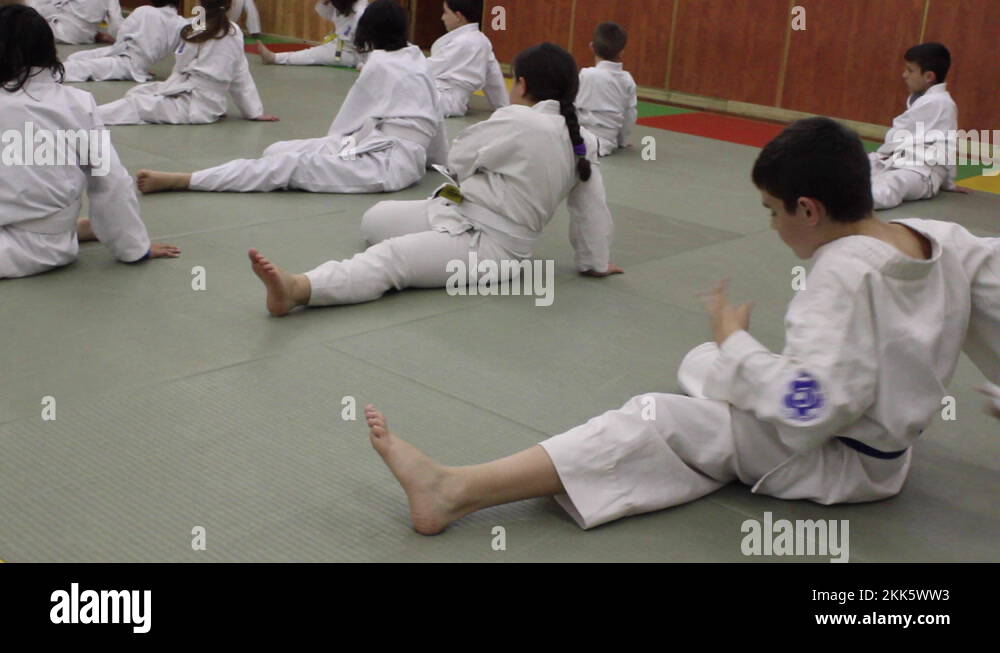 Karate Students in Class Stretch to Warm Up for Practice, White ...