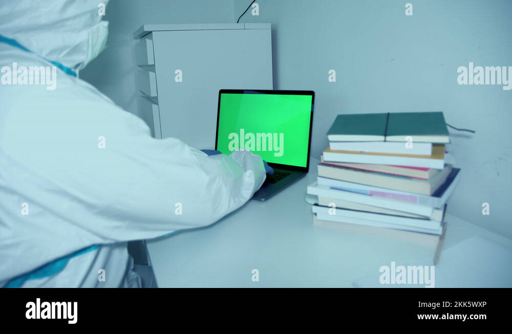 Hospital Worker In Full PPE Suit Working On A Laptop With Green Screen ...