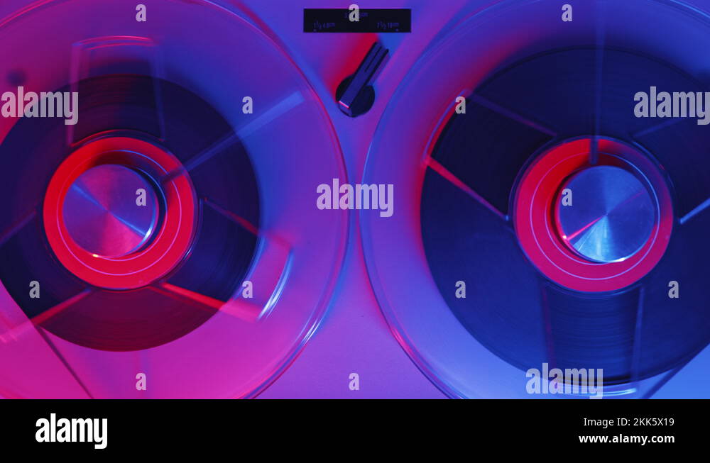 Reel to reel tape recorder playing ultra red blue neon light. Rotating ...
