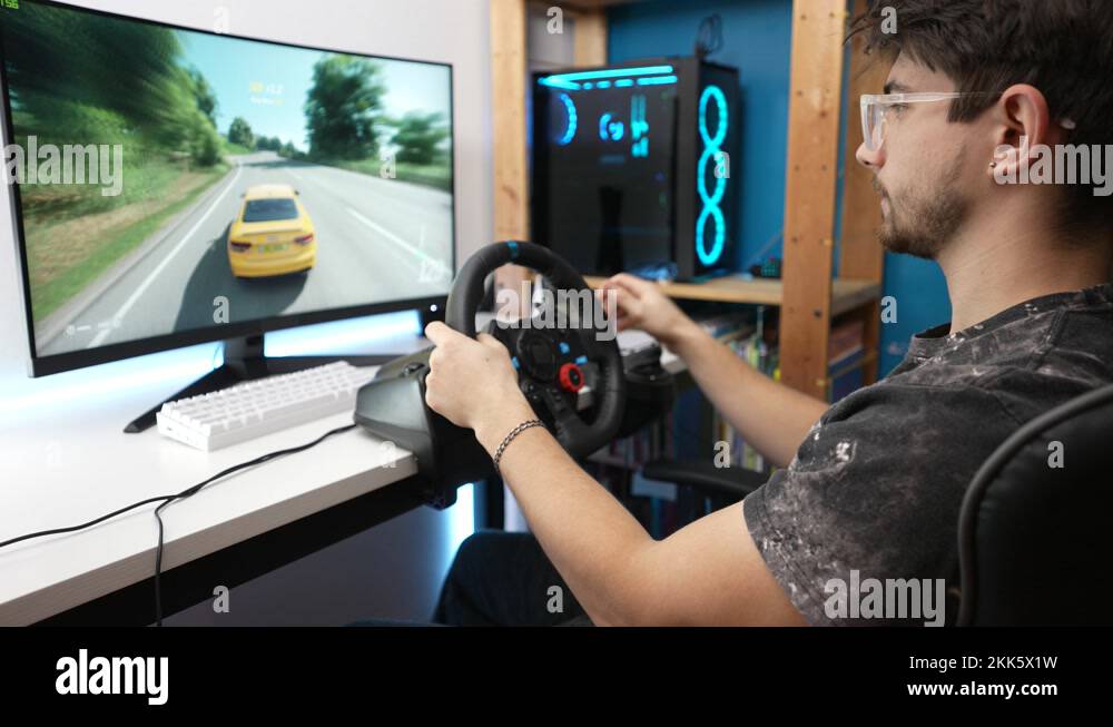 Male gamer sitting in the racing seat simulator cockpit with steering ...