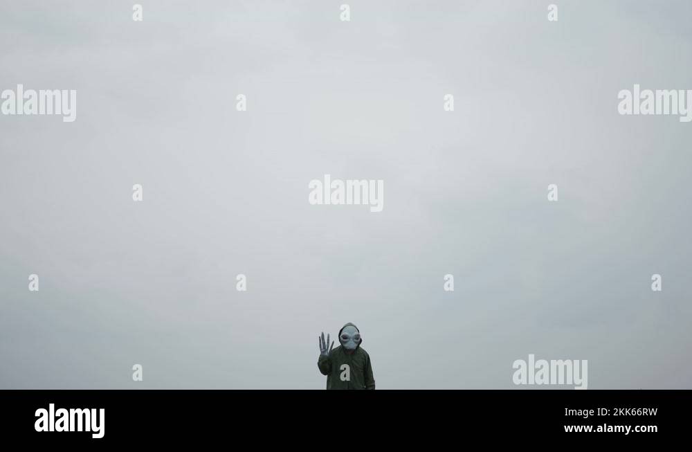alien in green suit stands alone in sky,alien arrived on earth rubbing ...