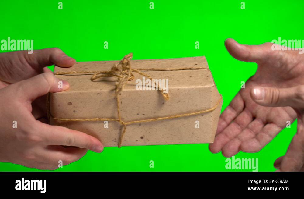 The courier hands over the parcel to the recipient on a green ...