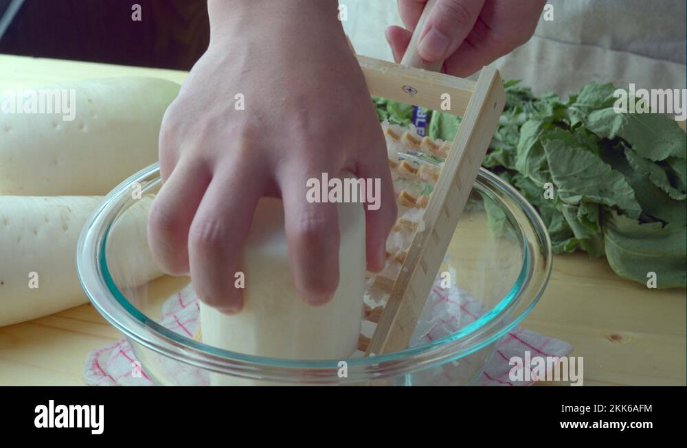 Grating daikon radish with traditional japanese bamboo grator Stock ...