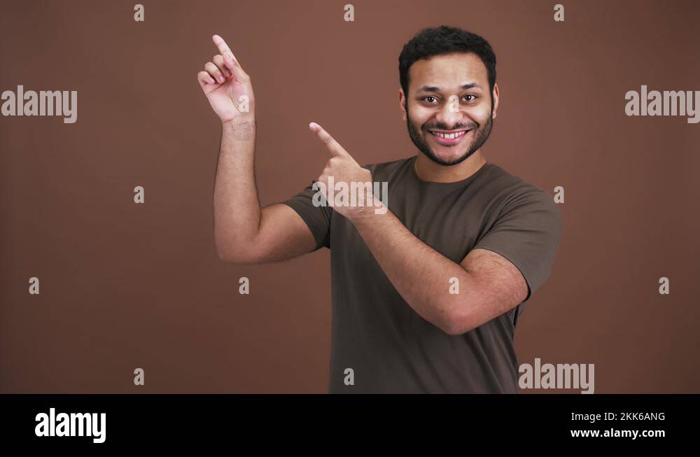 Emotional indian man pointing upward with enjoyment, nodding head as ...