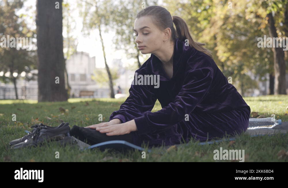 Positive slim beautiful young sportswoman touching toes stretching on ...