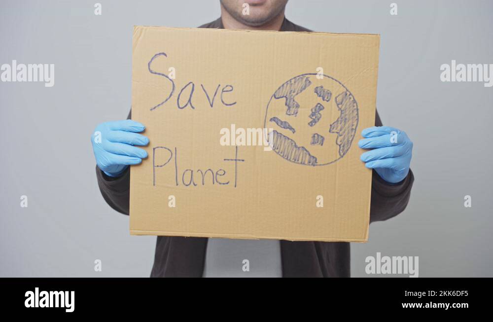 World environment day. Men wear rubber gloves and hold protest banners ...