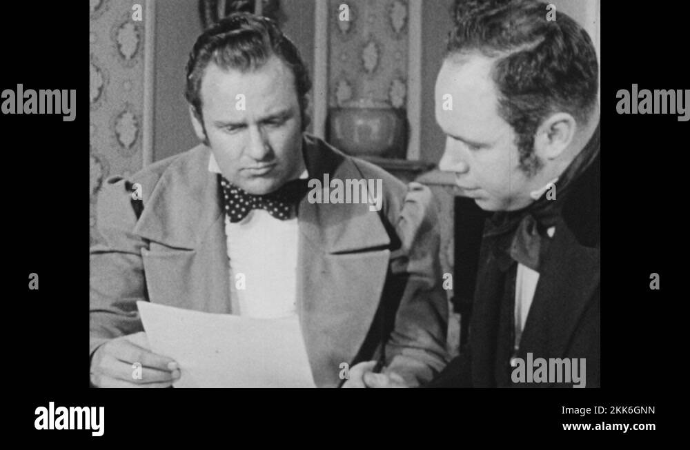 1950s: Men look at paper, speak and nod. Man enters room, nods and ...