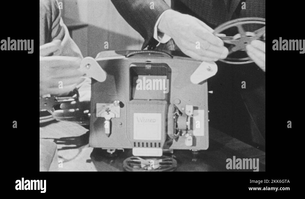 1960s: Hands put reels on projector, point to projector features. Man ...