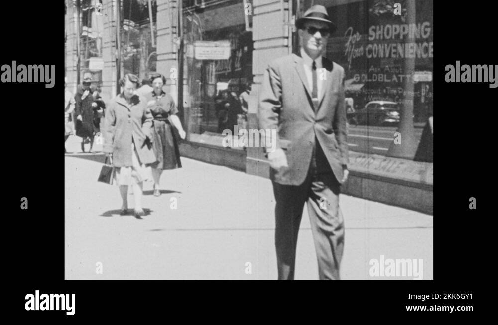 1960s: Shots of pedestrians on sidewalk. Pan of shopping center, women ...
