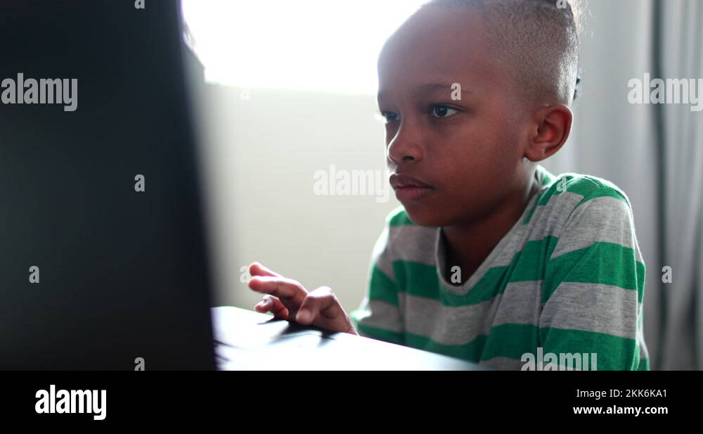 African boy studying from home in front of laptop computer Stock Video ...