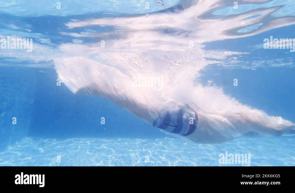 Athletic man head jumping in pool, huge splash with bubbles, underwater ...