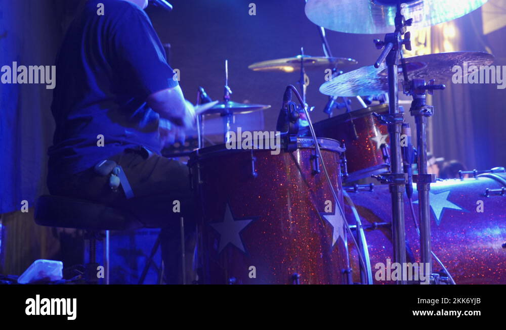 A drummer man playing on drum kit to audience. Rock perform on a ...