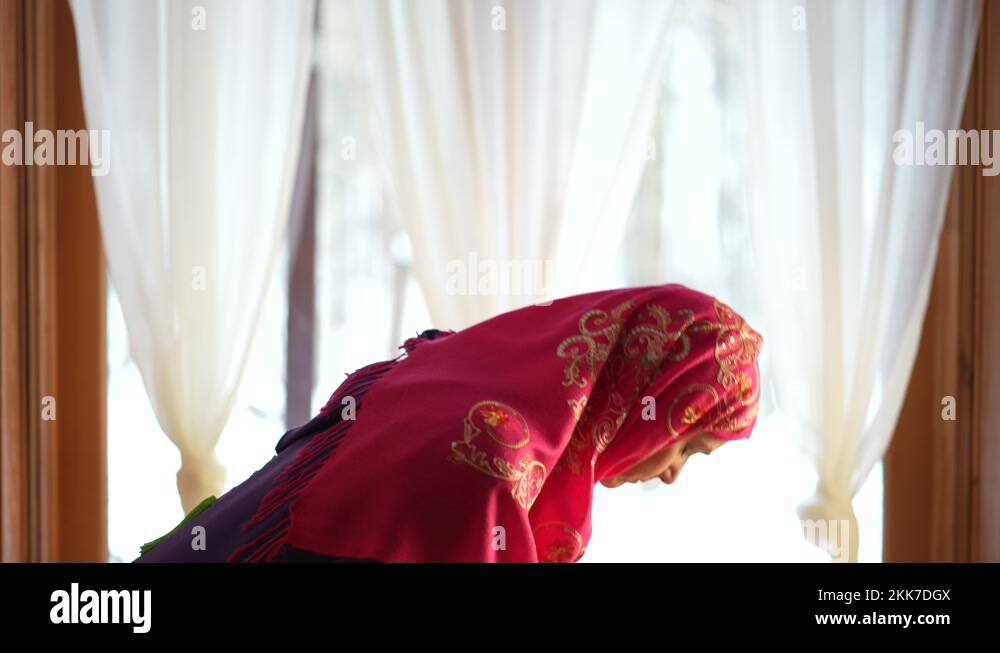 Mature Muslim woman praying at home with beautiful light with snow on ...