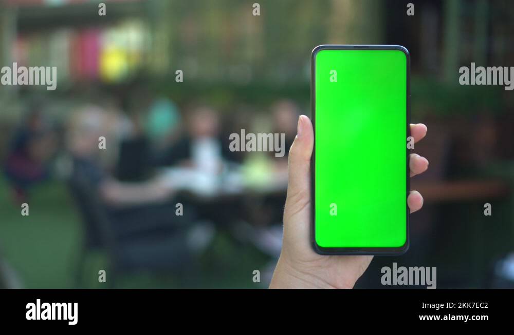 Close up hands woman holding phone with vertical green screen on busy street Stock Video Footage ...