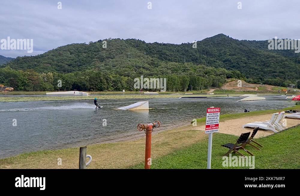 Adult Being Pulled By Rope And Jumping Ramp At Wakeboarding Park. Slow ...