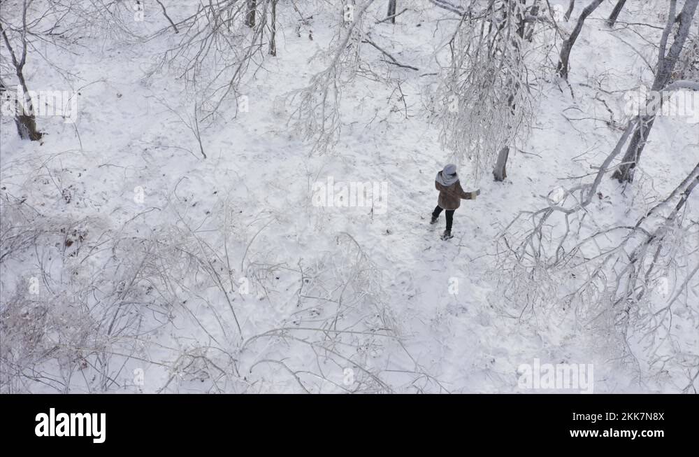 Woman dances in beautiful forest where trees are covered with ice after ...
