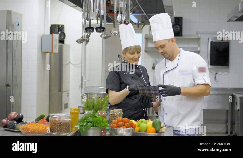 Restaurant chef makes a verification in kitchen. Interacting to head ...
