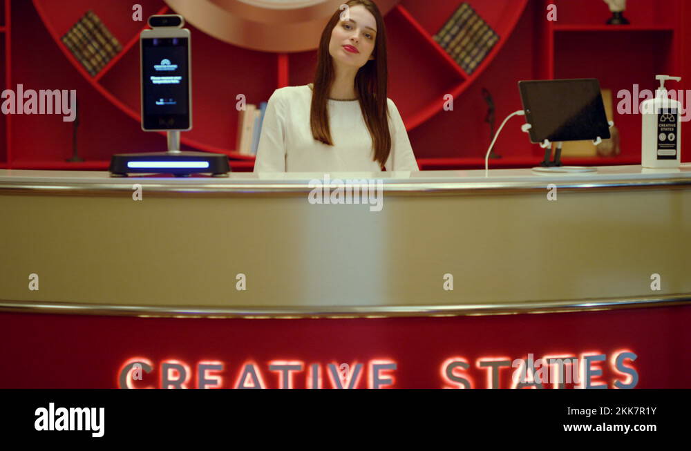 Receptionist standing at the hotel reception counter and smiling Stock ...