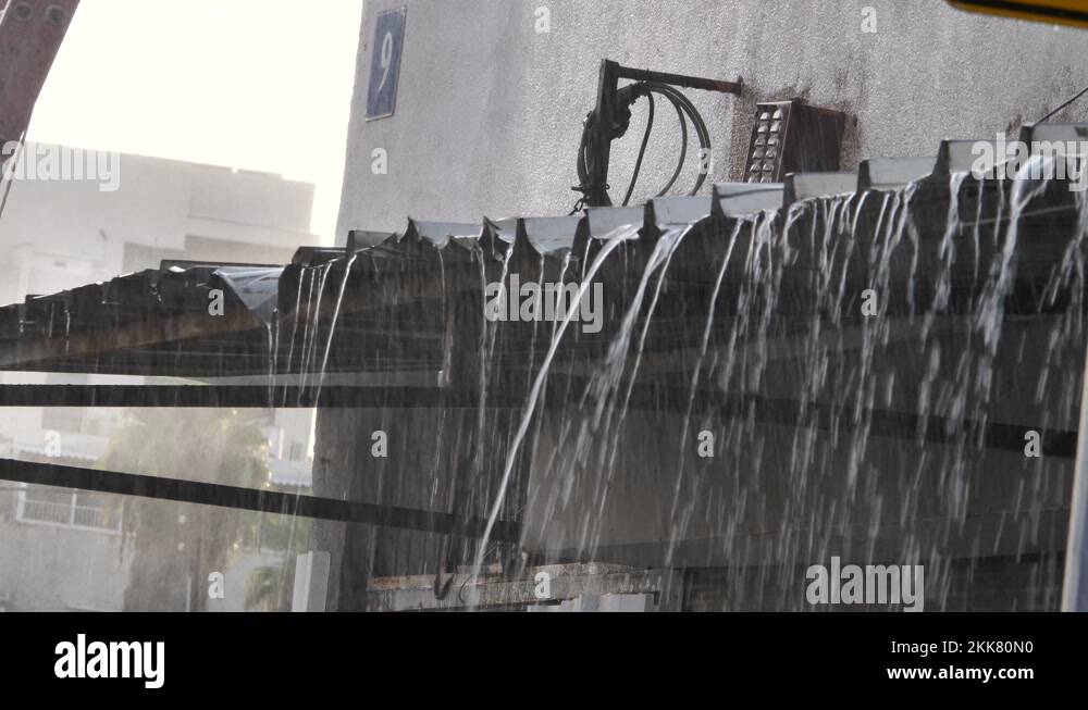 Water dripping from metal roof during extinguishing a burning building ...