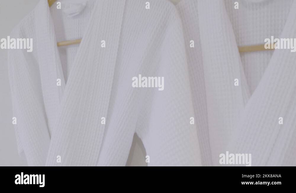 Two white robes hanging from a white wall of a hotel room Stock Video ...
