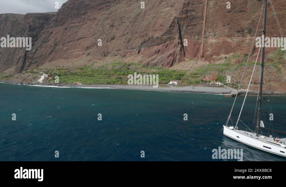 Sailing boat anchored in blue water surrounding Madeira island, aerial ...