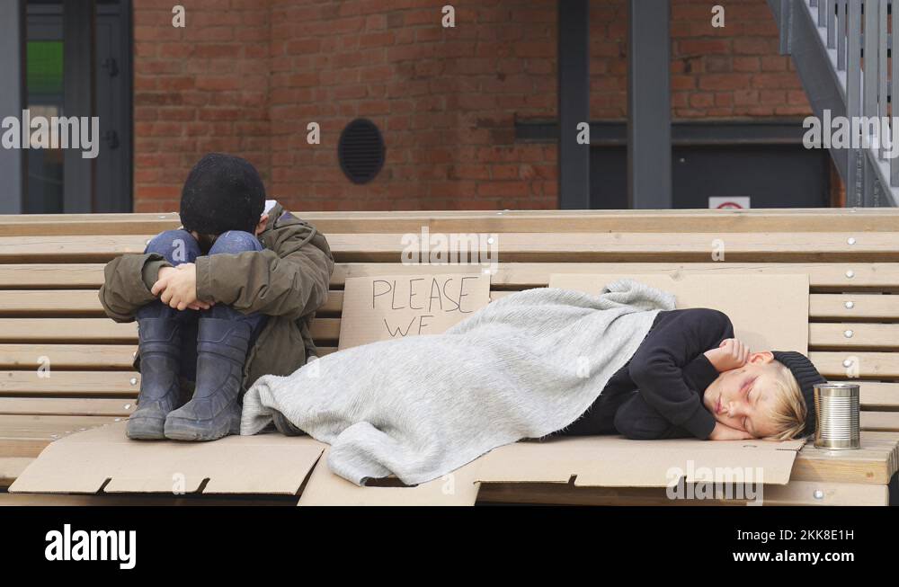 Two desperate street children asking for help in dirty town, on street ...