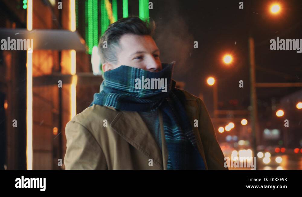 Man freezing from cold standing near roadway and shopping center at ...