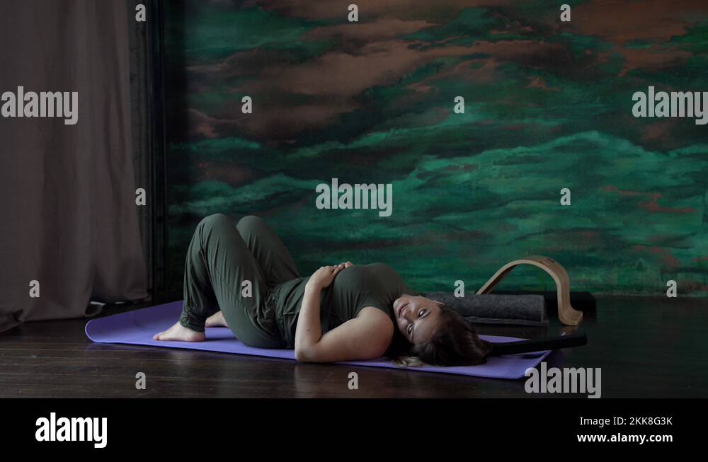 A woman does Pilates exercises and does leg lifts, exercises on a Mat ...