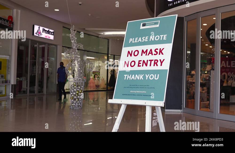 a teal sign in a mall reads "No mask No Entry". Christmas time during ...