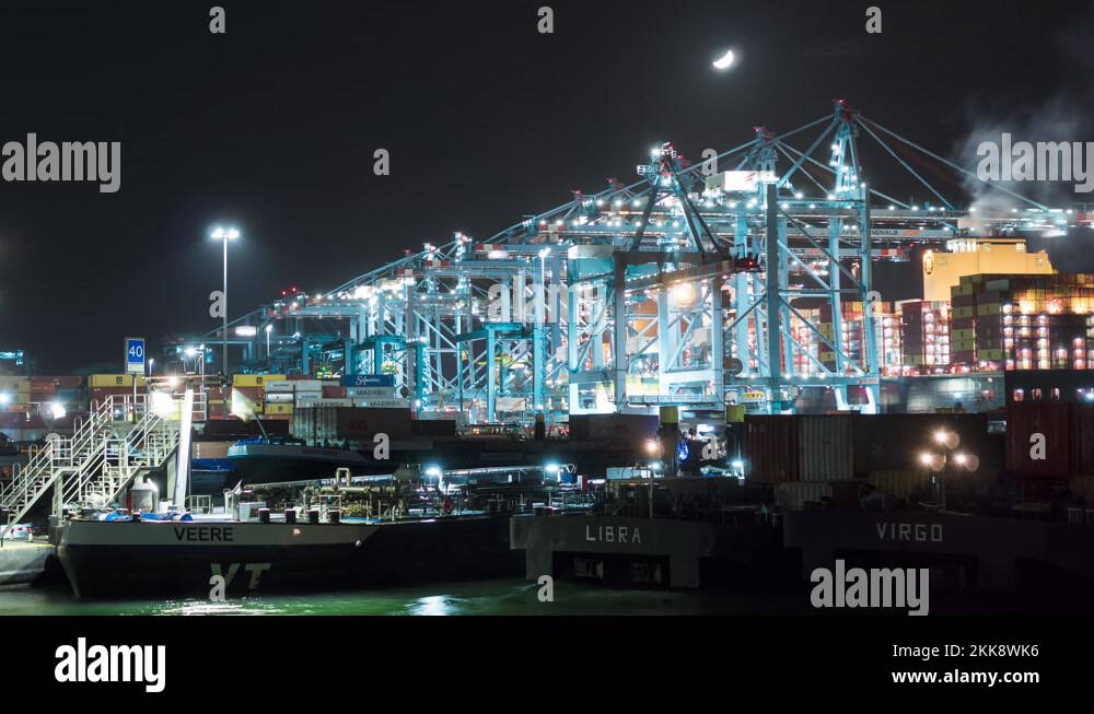 Busy port cranes terminal loading containers onto ship at night, time ...
