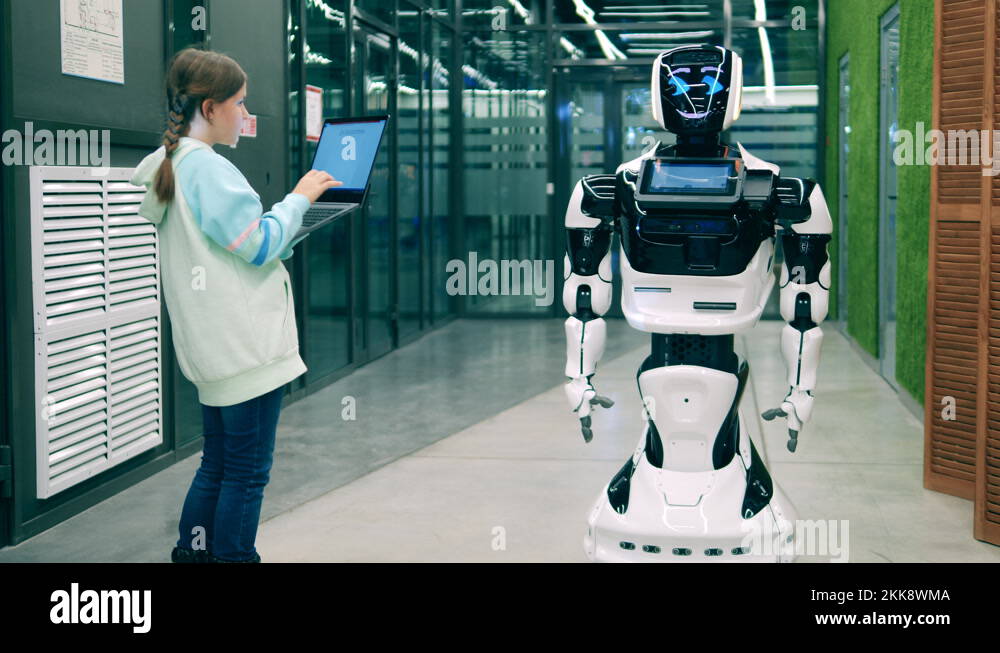 Girl with a laptop is operating a robot Stock Video Footage - Alamy